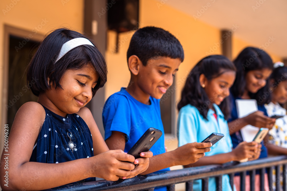 Group of kids busy using mobile phone at school corridor - concept of ...