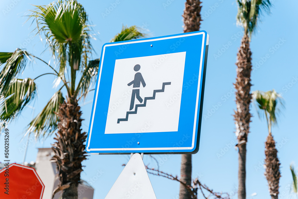 Underground walkway street sign with blue sky and palm trees in ...