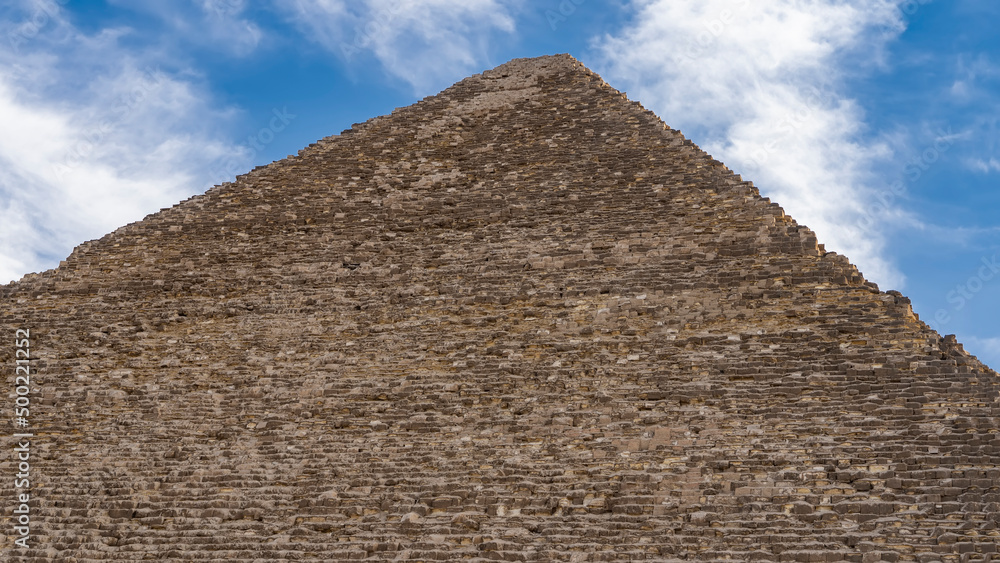 The Great Pyramid of Cheops on a background of blue sky and clouds. The ...