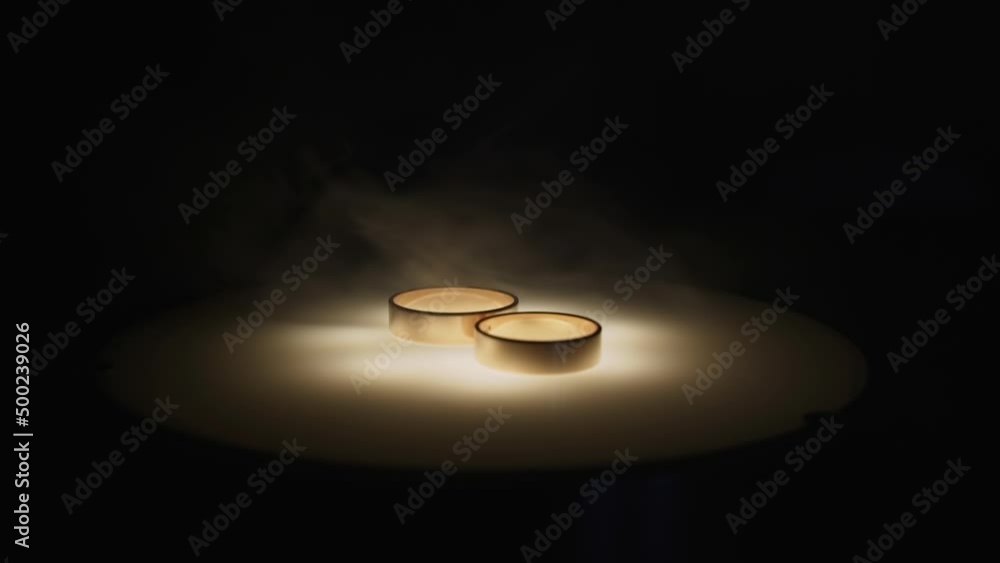 Vídeo do Stock: Two gold wedding rings lie side by side on luminous ...