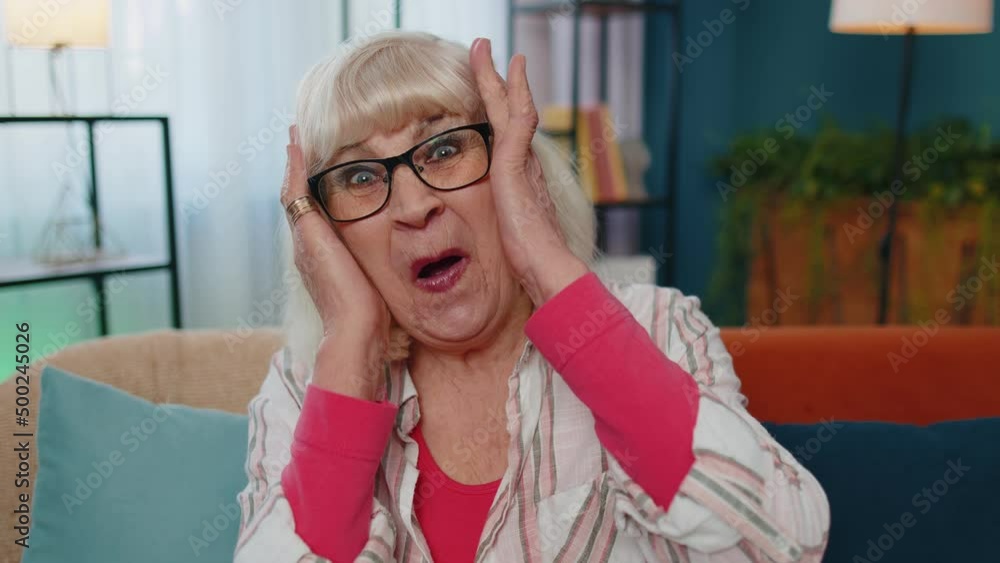 Oh my God Wow. Excited amazed senior old grandmother raising hands in ...