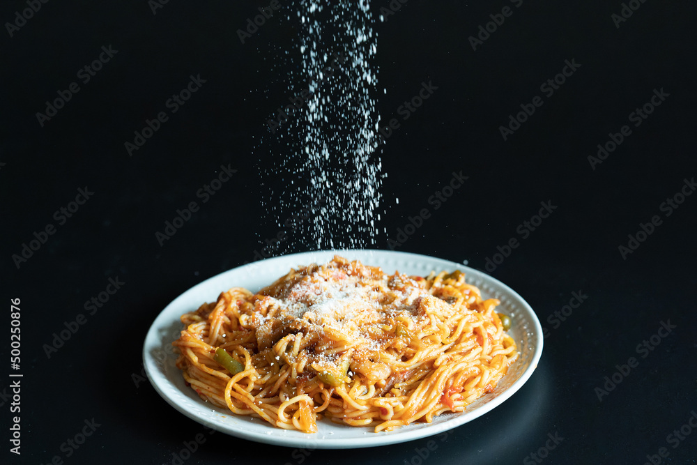 Sprinkle cheese on spaghetti Stock Photo | Adobe Stock