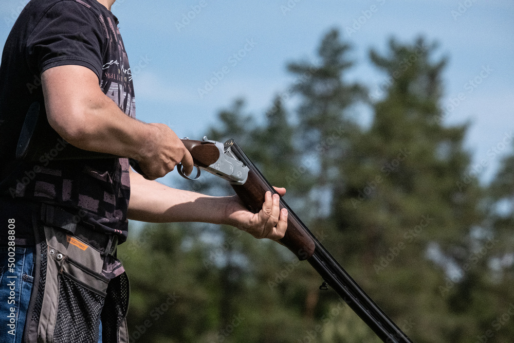 Hunting rifle firing. Hunting in the forest. Hunter loading gun with ...