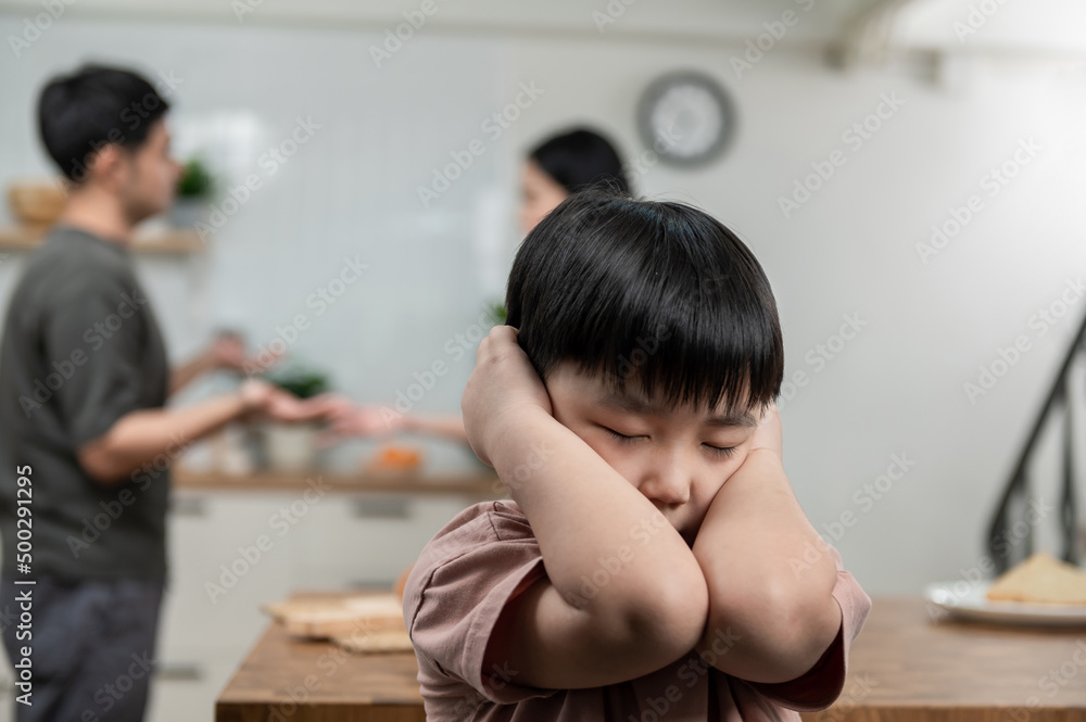 Young little Asian kid feel sad upset, boring while parent fighting ...