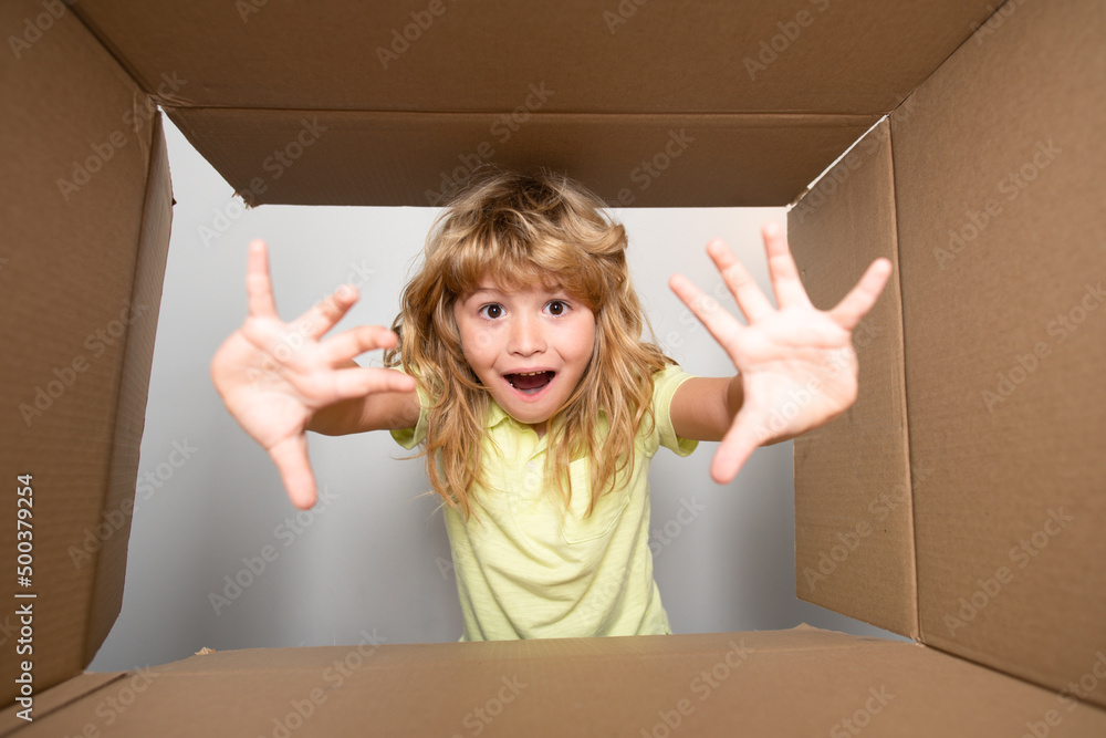 Foto de Child opens carton box and pulling out gift from it. Small boy ...
