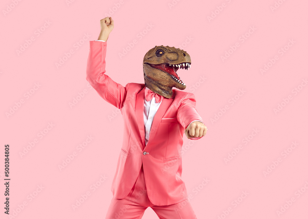 Funny confident man wearing rubber dinosaur mask dancing at show or ...