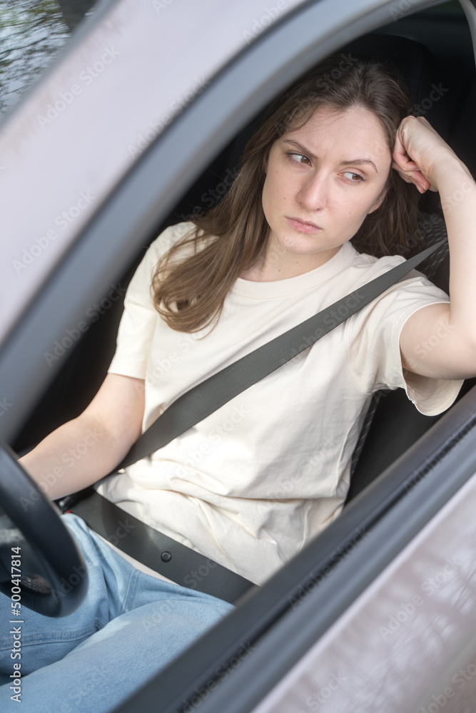 Anxiety and stress. Woman driver behind the wheel of the car is upset ...