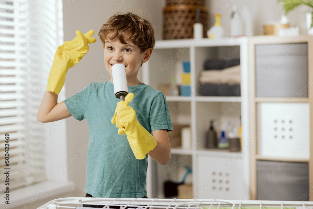 A little boy fools around while cleaning the bathroom. The child has ...