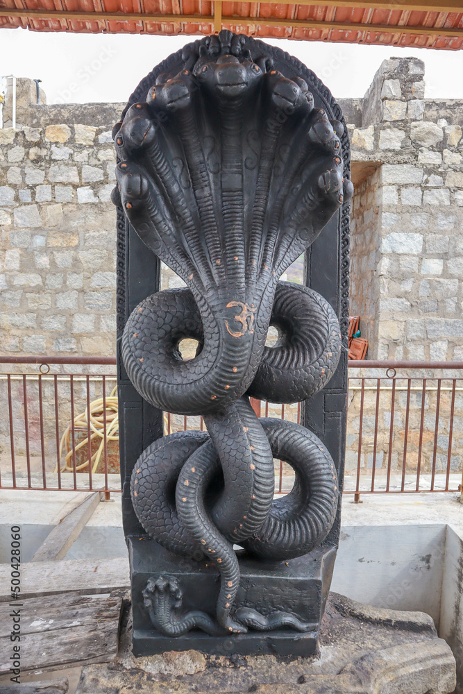 An aesthetically carved sculpture of the Snake God Naga in black stone ...