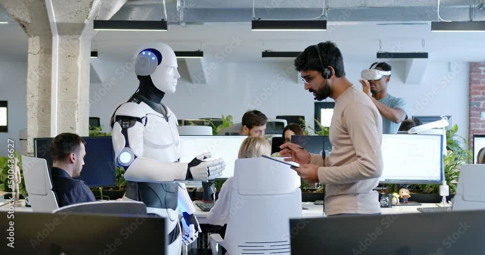 Indian man speaking to robot in office. Male developer checking work ...