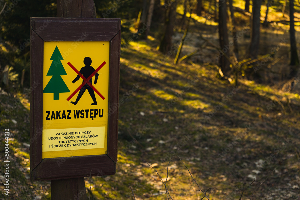 Wodden sign with written Entrance Into the Forest Prohibited, standing ...