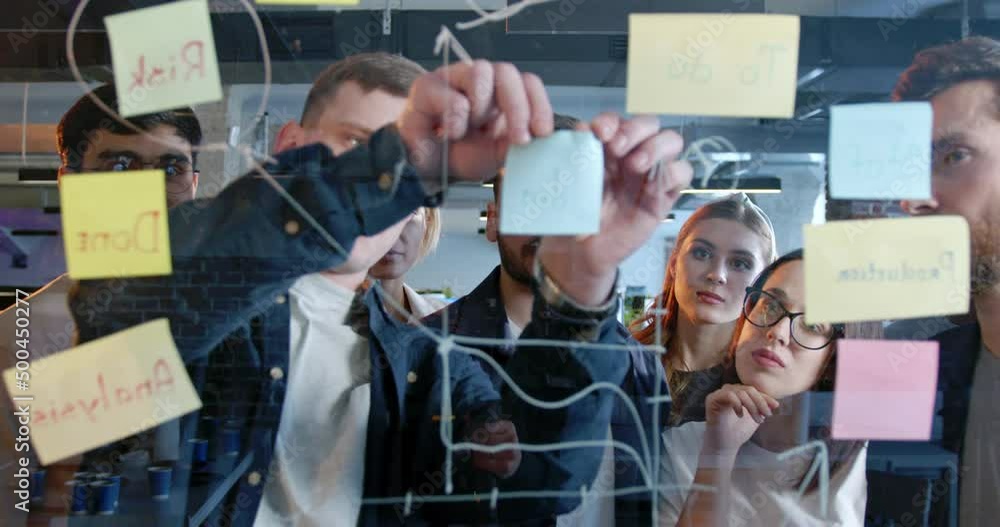 Diverse people of project standing in front of tasks and to-do notes ...