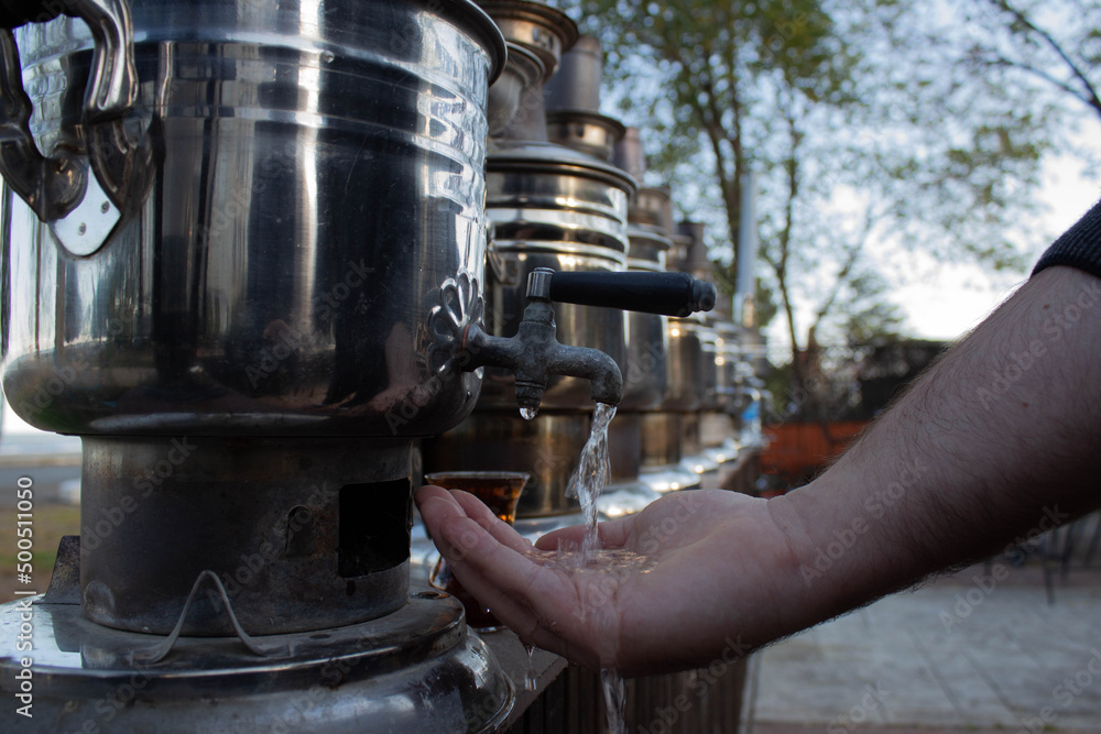 Man hand washing water from tea urn. Cleaning hands for food ...