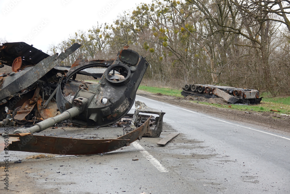 An exploded tank on the road. The armored vehicles burned down. The war ...