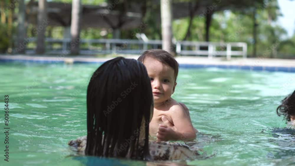 Vidéo Stock Mom and baby are having fun in the pool, the baby is in ...