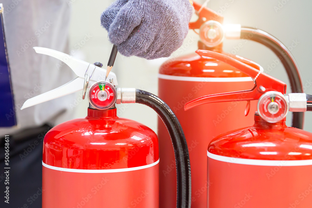 Fire extinguisher has hand engineer inspection checking pressure gauges ...