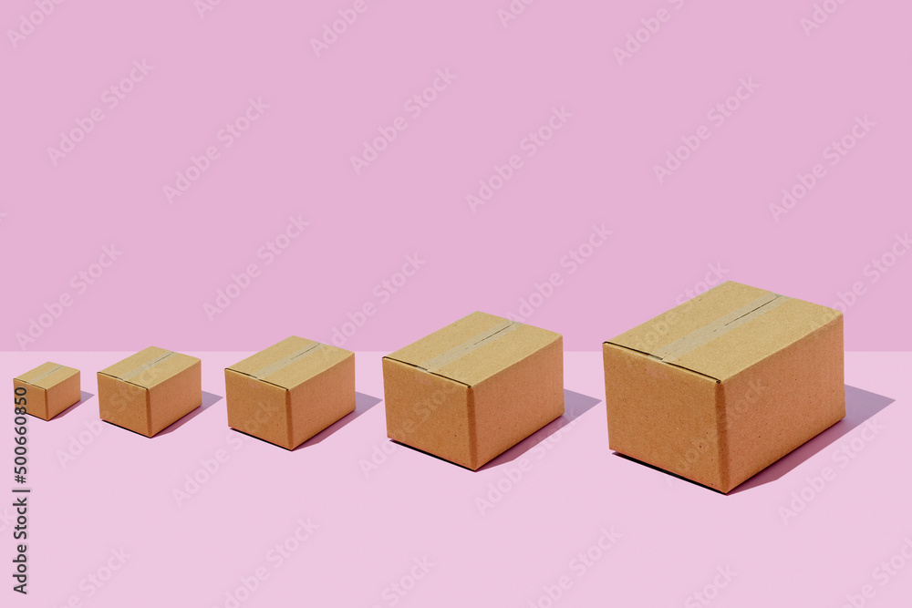 Cardboard boxes of different sizes in a row on a purple background ...