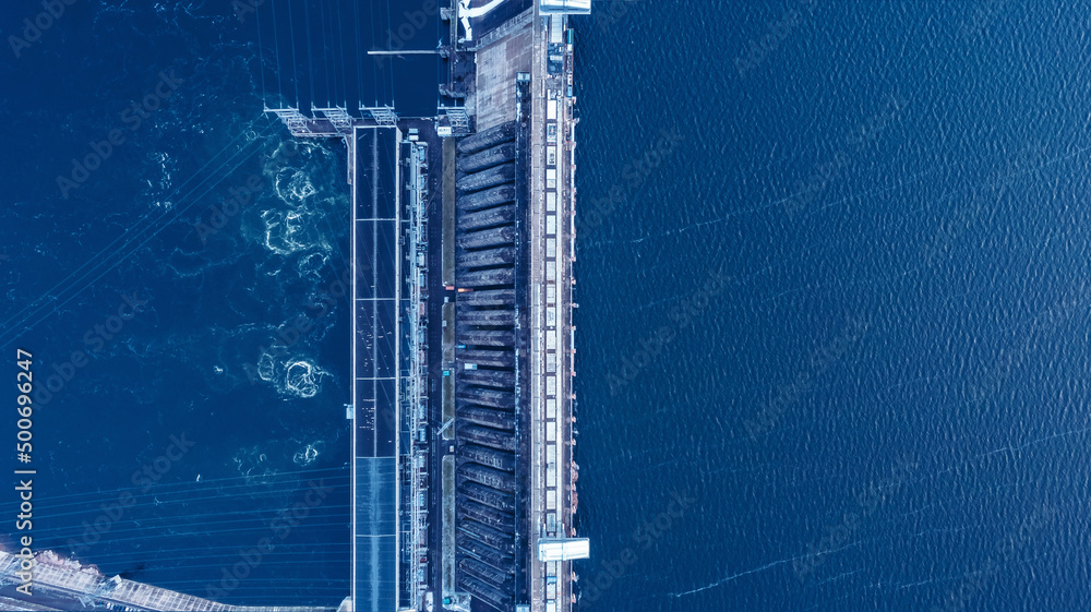 Aerial top view hydroelectric dam, water discharge through locks, blue ...