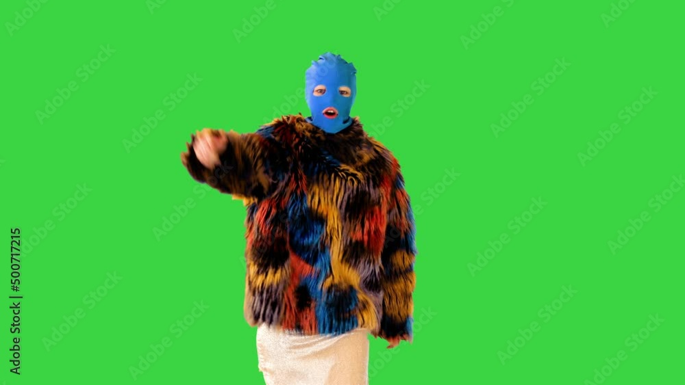 Defiant girl in balaclava walks, making some energetic hand gestures on ...