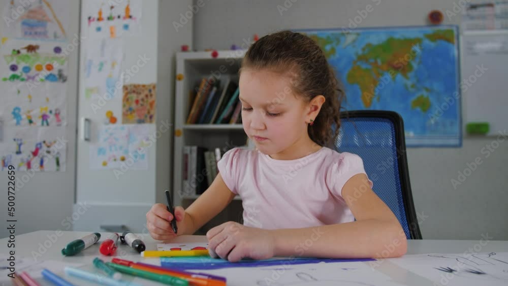 Little kid girl study at home, drawing picture by markers, playing ...