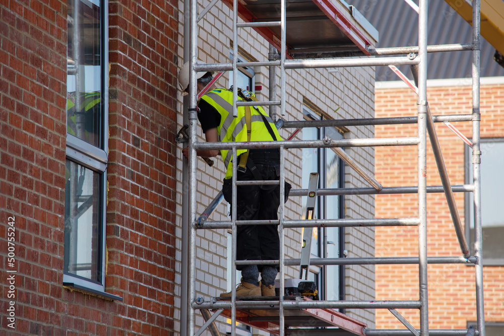 Construction workers using aluminium mobile scaffold tower and safety ...