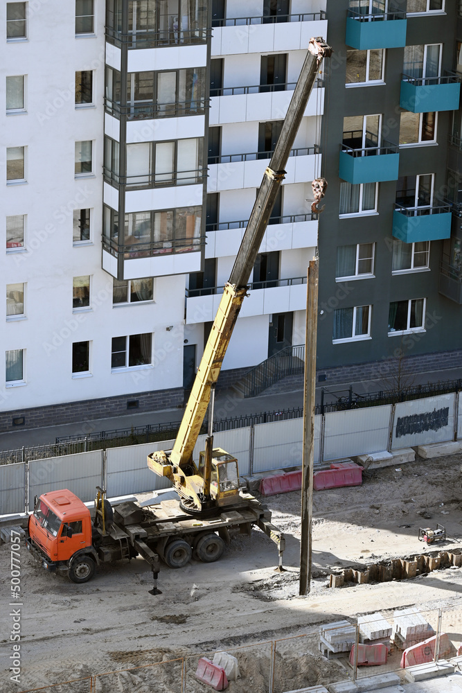 Immersion of a sheet pile by an excavator using a vibrating loader on a ...