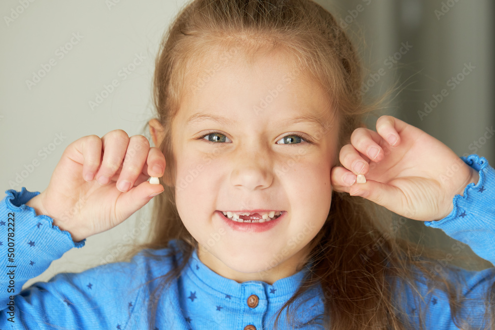 Toothless child. Cute little girl smiles broadly. The first milk tooth ...