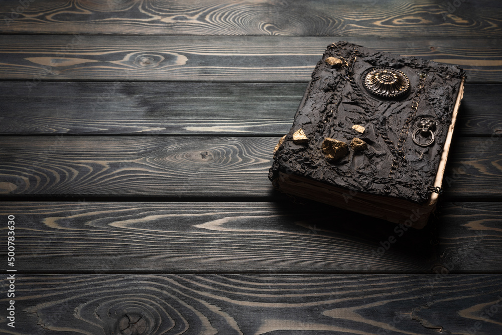 Ancient magic book on the old wooden table background with copy space ...