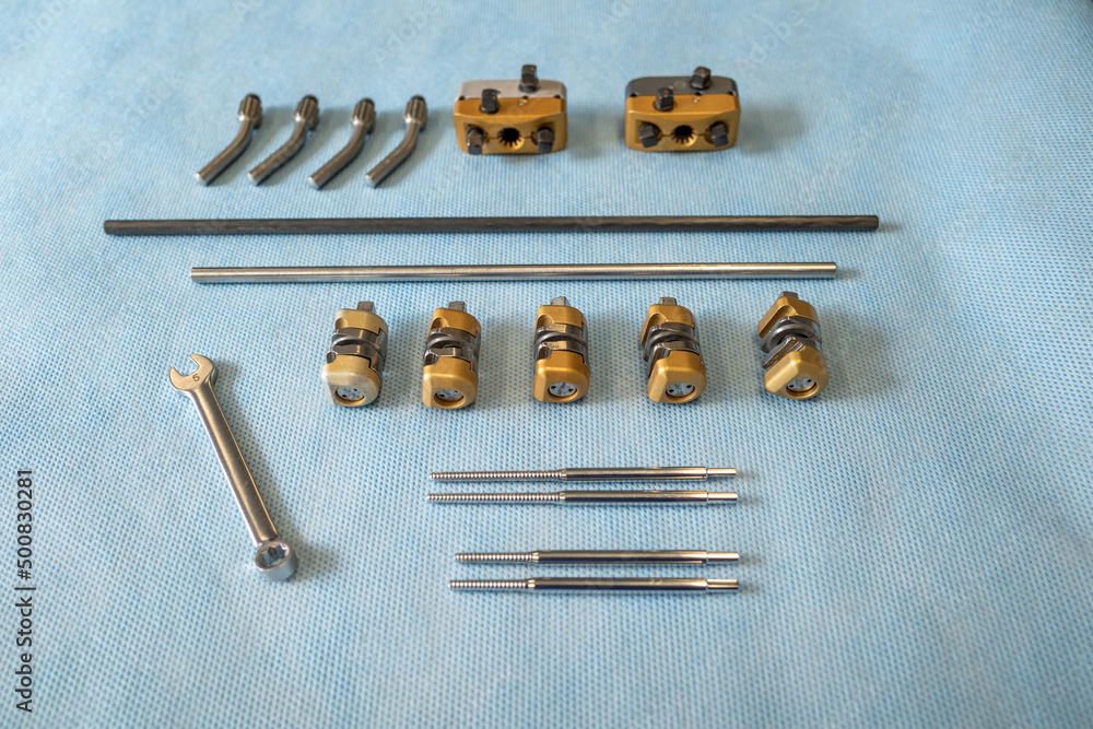 single parts of a surgical hand fixator lie on a blue surgical cloth ...