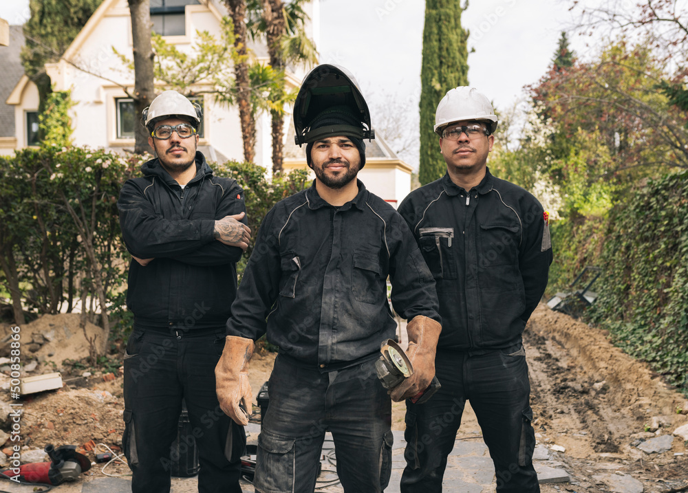 Smiling workers with grinders and work tool at construction site Stock ...