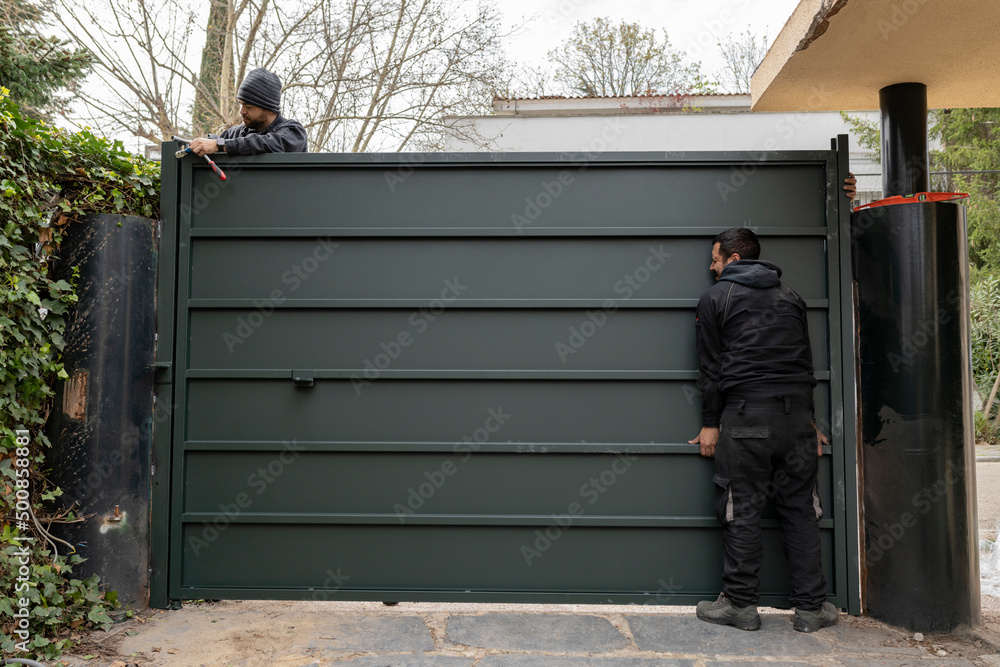 Construction worker working on metal gate at construction site Stock ...