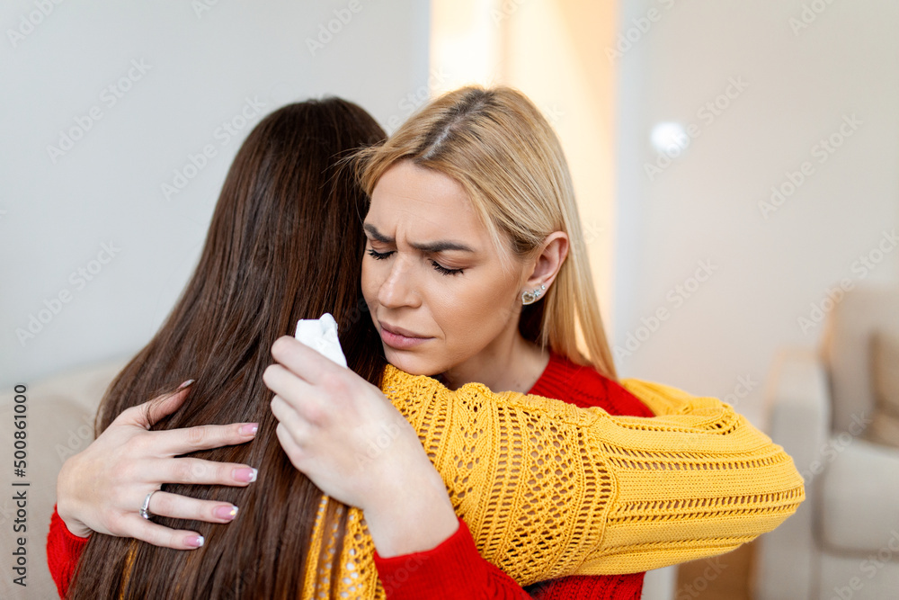 Woman hugging her depressed friend at home, closeup. Young woman ...