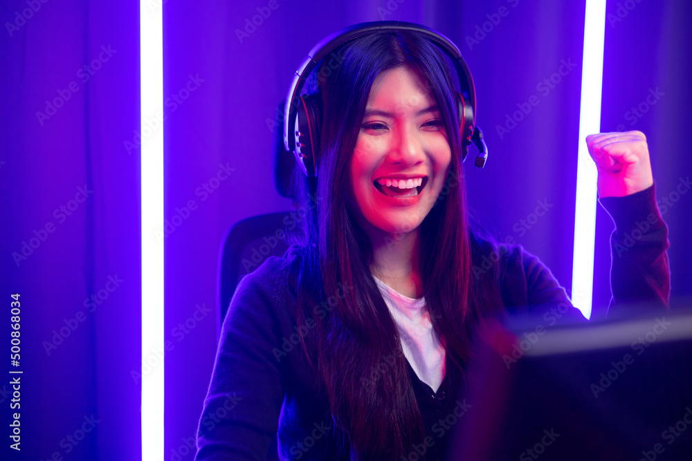 Pro gamer. Young pretty asian woman sitting on chair playing computer ...