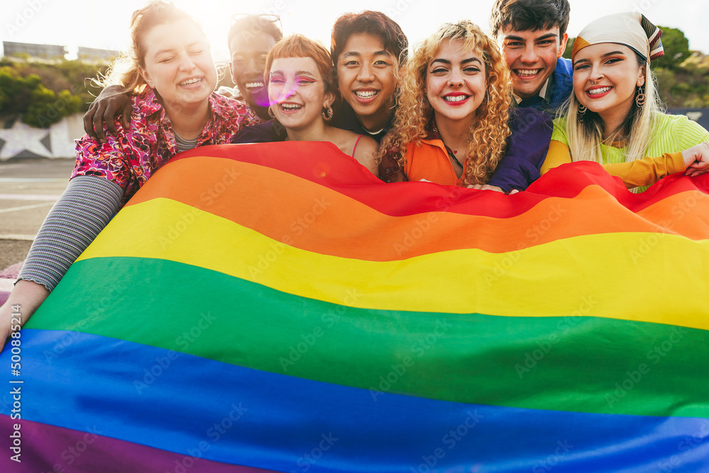 Young diverse people having fun holding LGBT rainbow flag outdoor ...