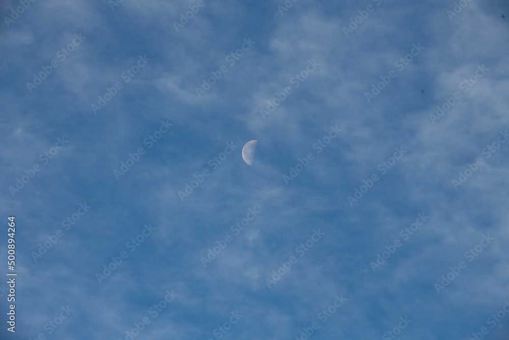 Zdjęcie Stock: photo of half moon in blue but partial cloudy sky in ...