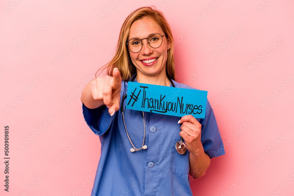 Young nurse woman holding thank you nurses placard isolated on pink ...