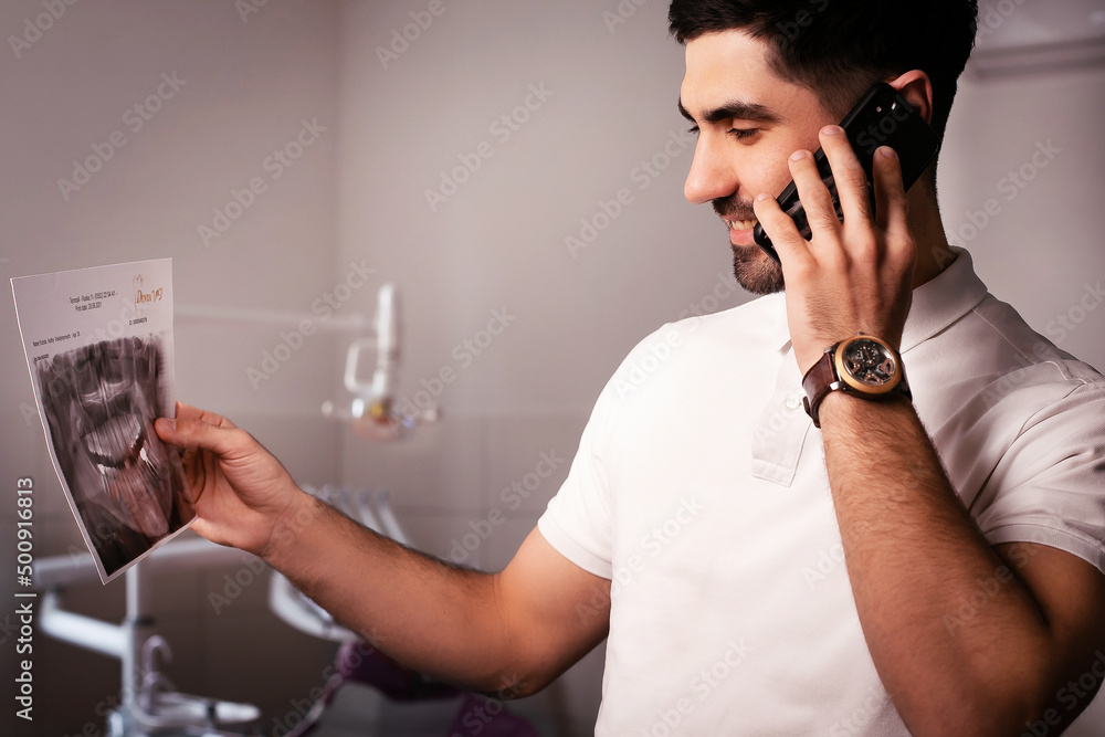 Dentist looking an X-ray of jaw with an implanted tooth. talking on the ...