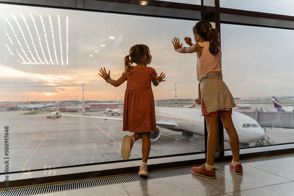 Little sister girls together at the airport waiting for boarding near ...