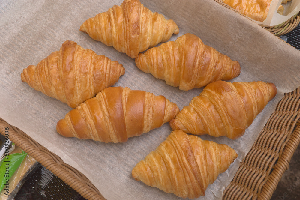 Classic French croissant or butter croisant in wooden basket,which is ...