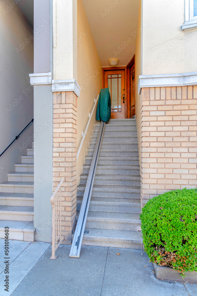 Front entrance of a house with stair lift on a concrete stairs leading ...