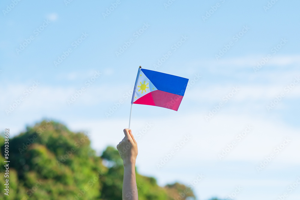 hand holding Philippines flag on nature background. 12th June of ...