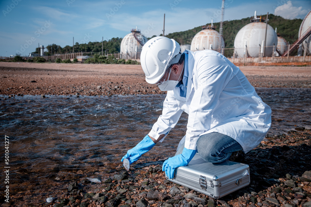 Scientist wearing safety uniform and glove under working water analysis ...