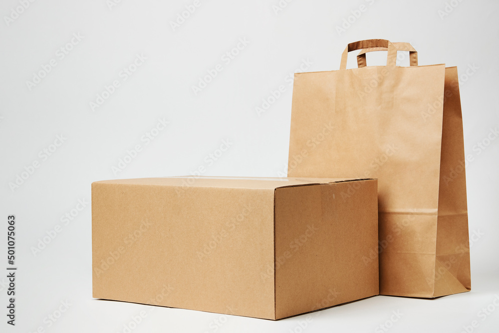 Cardboard box and paper bag on isolated on white Stock Photo | Adobe Stock