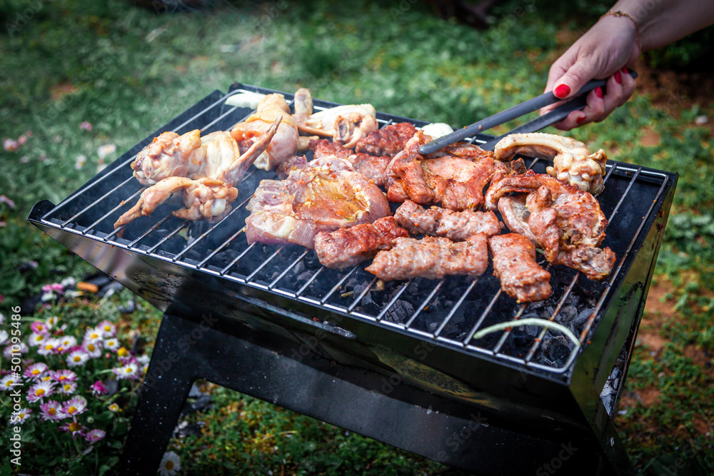 Foto de Making barbeque in nature. Barbecue with meat and fire for ...