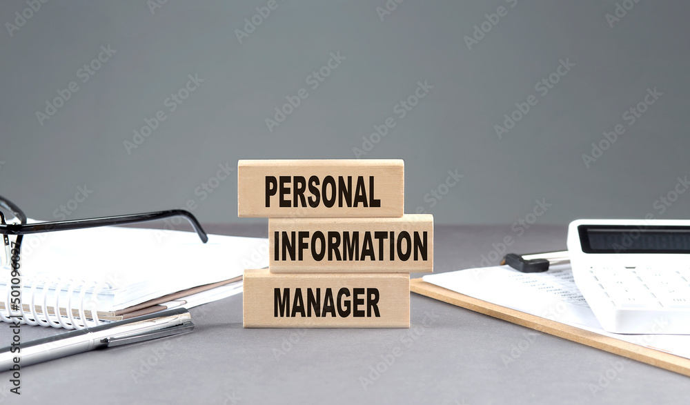 PIM Personal Information Manager text on wooden block with notebook ...