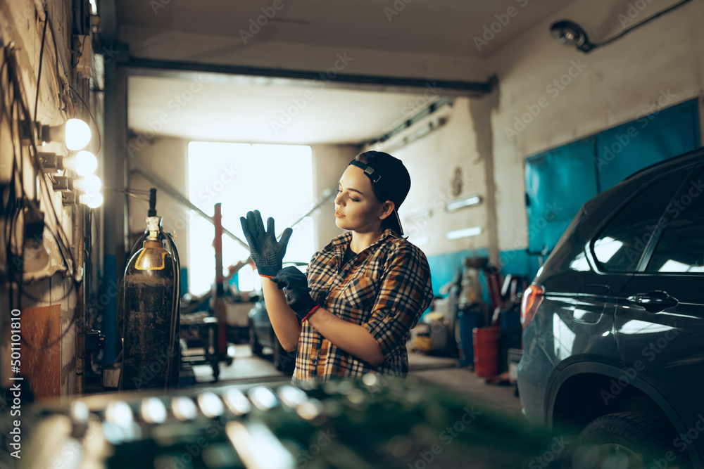 Destroying gender stereotypes. Young woman auto mechanic working at ...