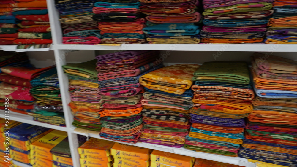 Colorful sarees or saris are arrange on racks and display in a retail ...