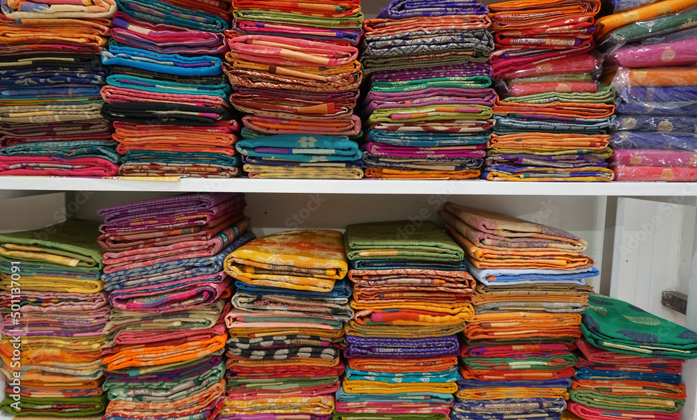 Colorful sarees or saris are arrange on racks and display in a retail ...