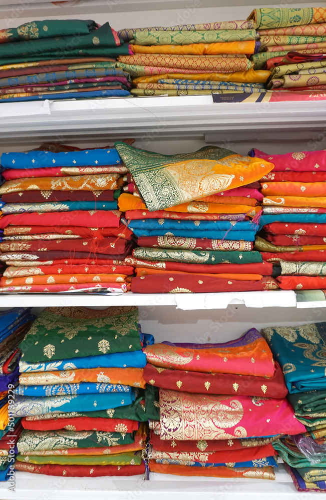Colorful sarees or saris are arrange on racks and display in a retail ...