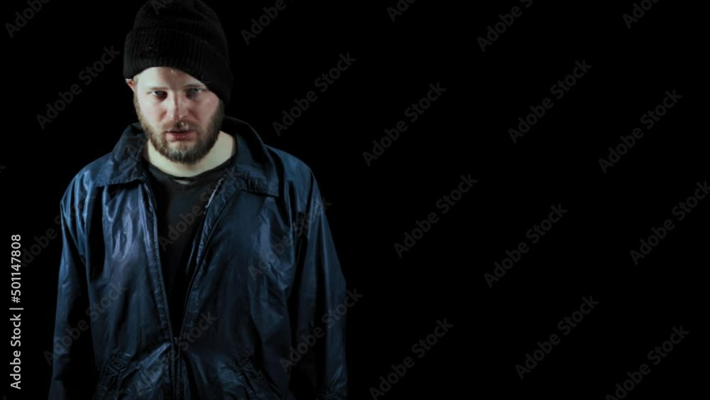 Bearded homeless points to empty space on black background, copy space ...